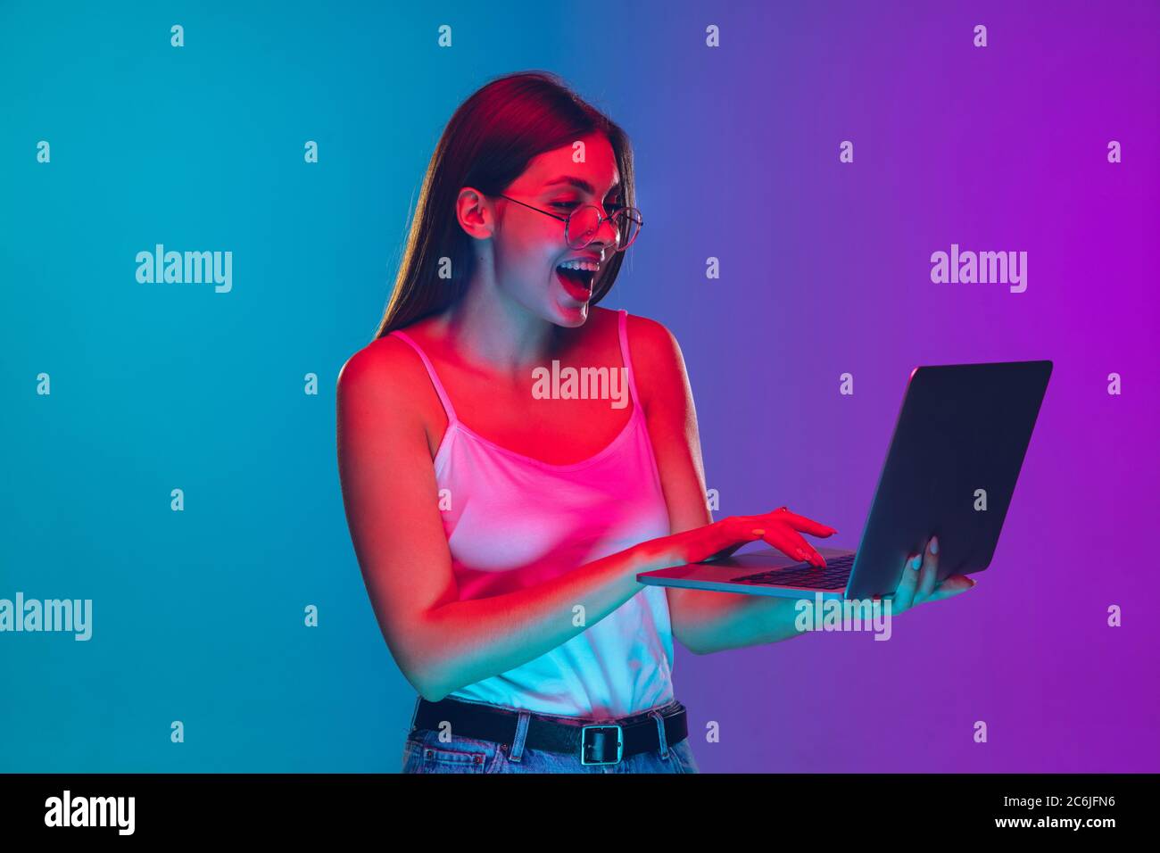 Laughting. Typing, using laptop. Caucasian young woman's portrait on ...