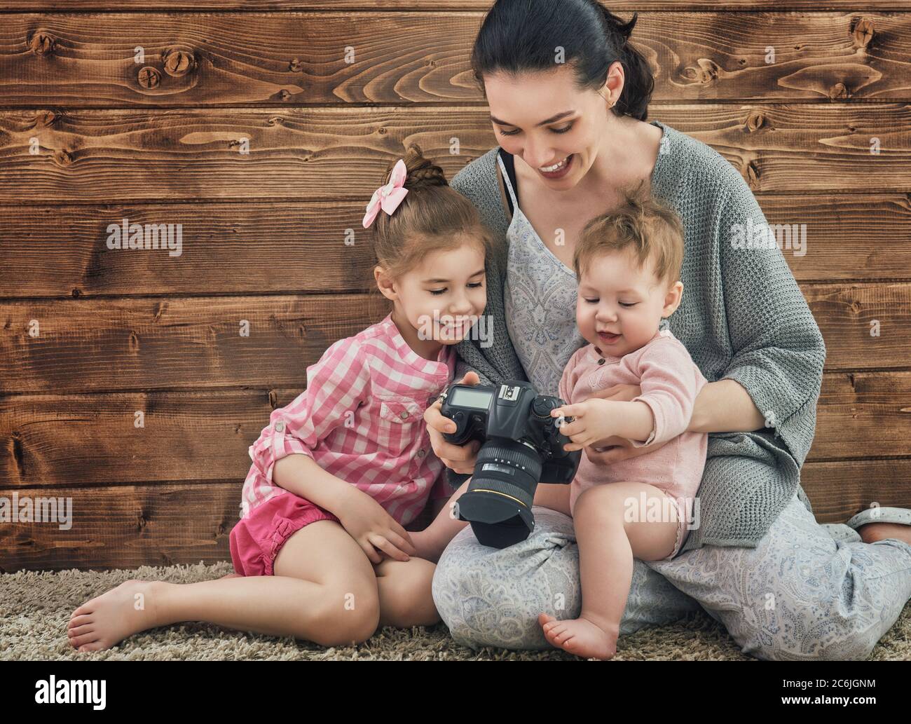 Photographer in motion. Young woman photographer and children girls ...