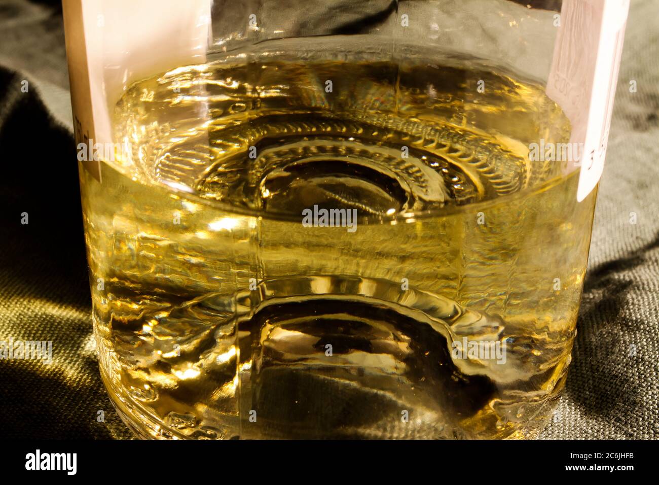 View on lower part of isolated white wine bottle with leftover fluid on ...