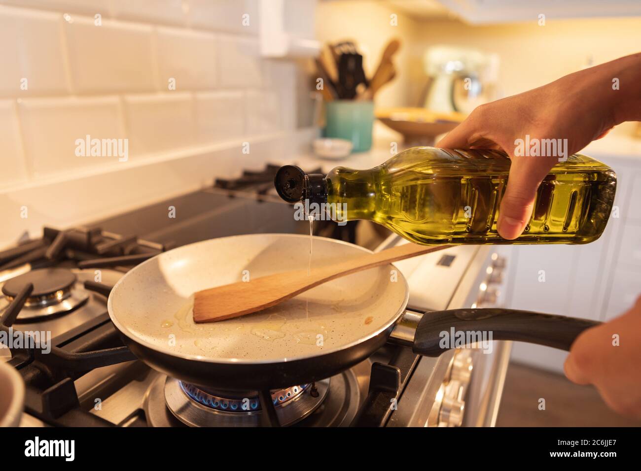 Mid section of woman pouring oil on frying pan Stock Photo - Alamy