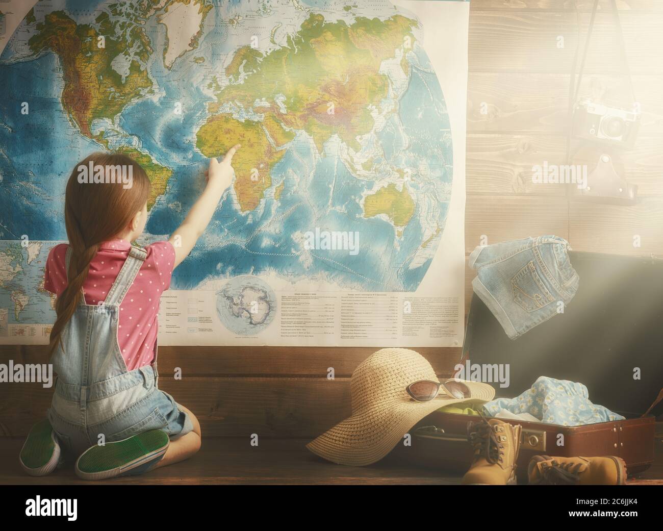 Happy child girl getting ready for the journey. Girl packs her bags and ...