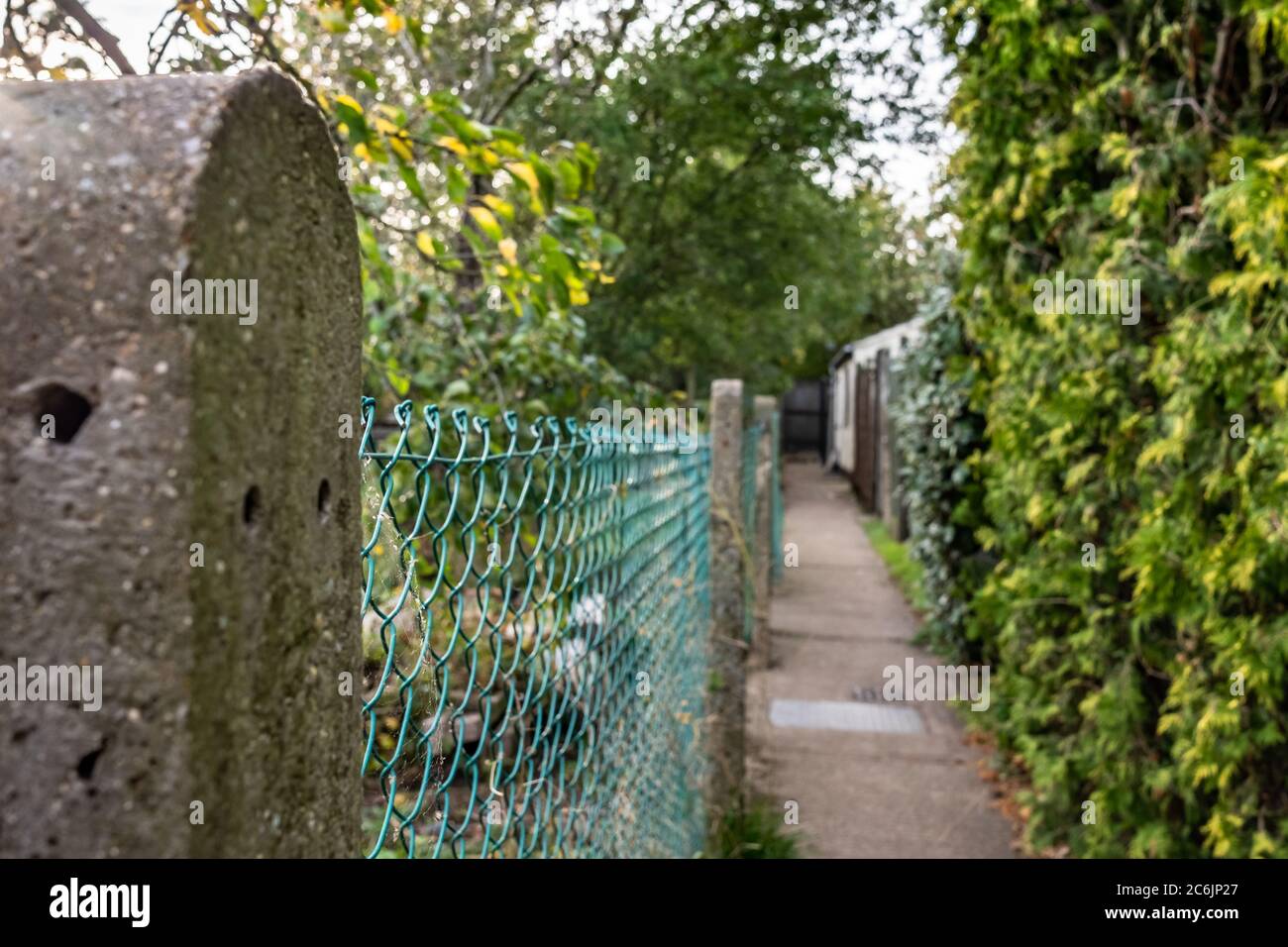 Close-up, shallow focus view of a concrete fence post showing a rusty ...