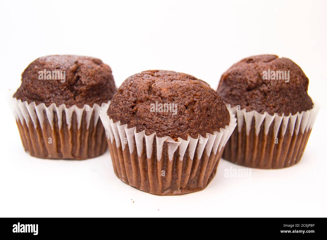Three chocolate muffins on a white background Stock Photo - Alamy