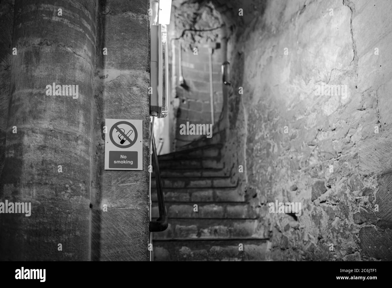 Dark and eerie scene of a very old, stone staircase within the confines ...