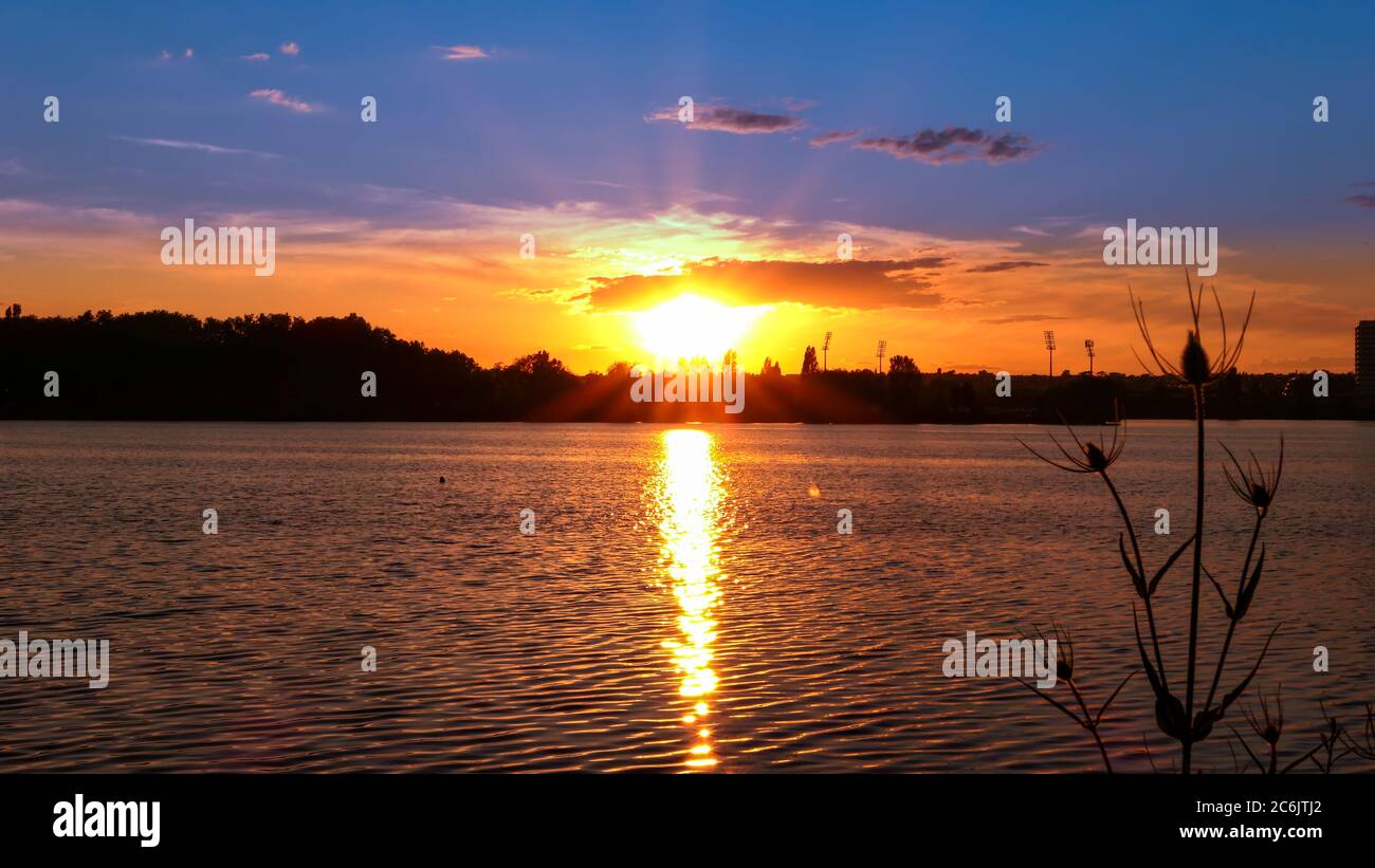 Amazing sunrise over a lake. Rays of the sun reflecting on the water ...