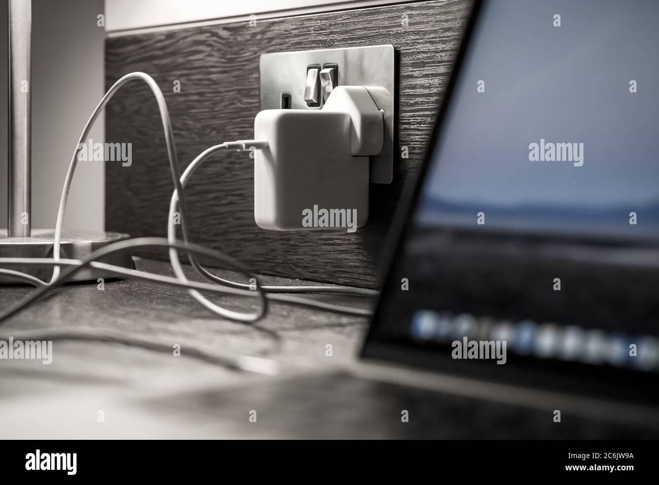Well known, metal encased laptop computer seen on a hotel wooden desk ...