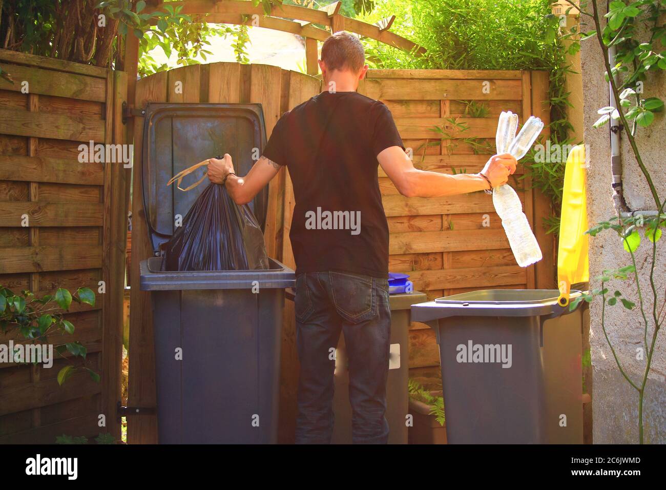Person performing a selective sorting of household waste in recycling ...
