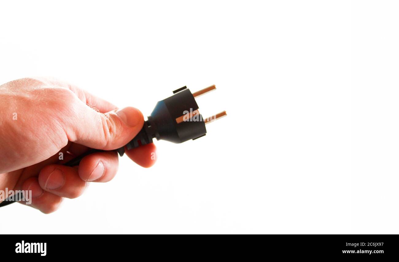 Person holding black electric plug. Cable in hand isolated on white ...