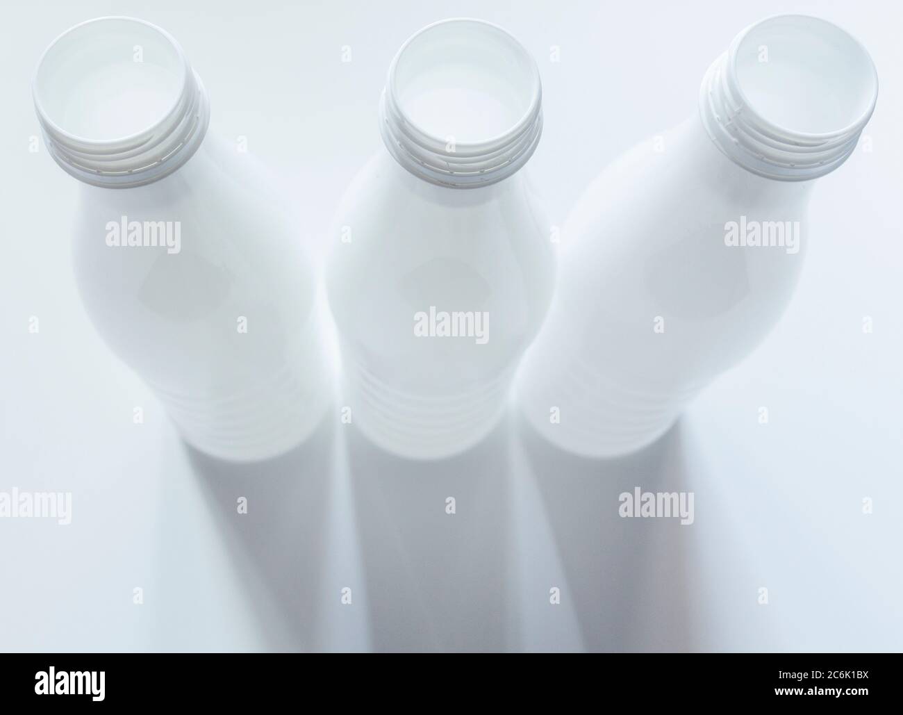 Open empty white plastic milk bottles on White background Stock Photo ...
