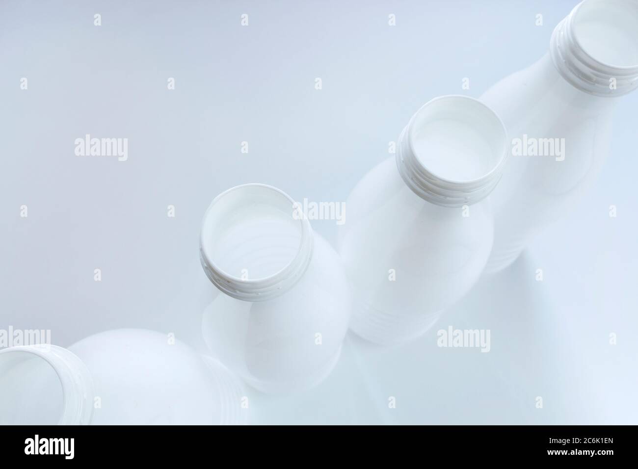 Open empty white plastic milk bottles on White background Stock Photo ...