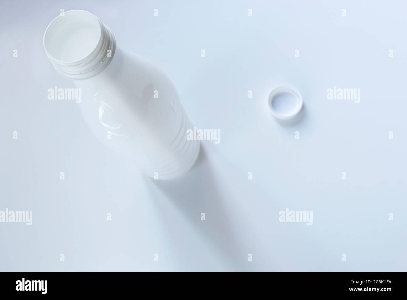 Open white plastic milk bottle and cap on White background Stock Photo ...