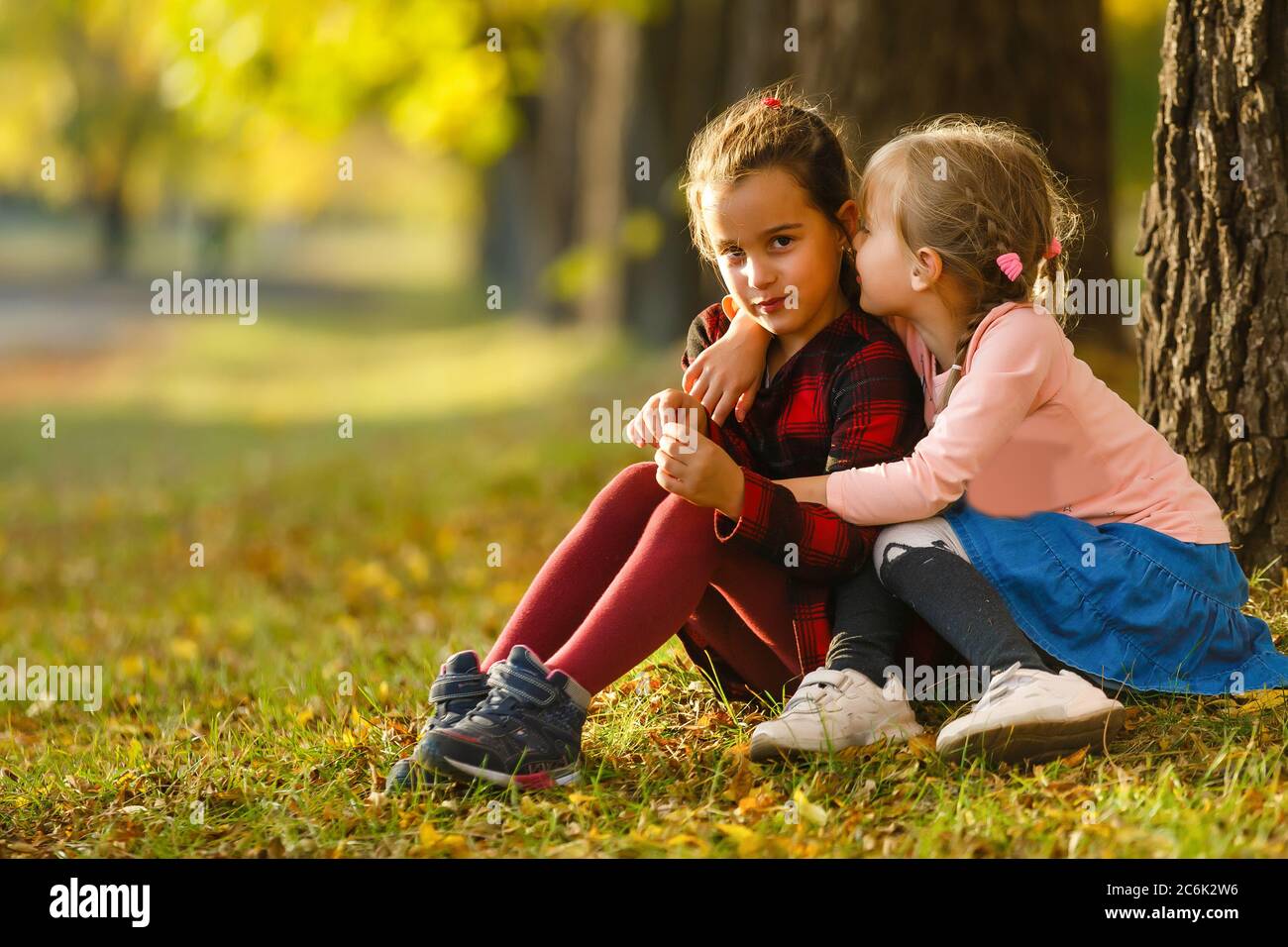 Two little girl friends schoolgirl in the park Stock Photo - Alamy