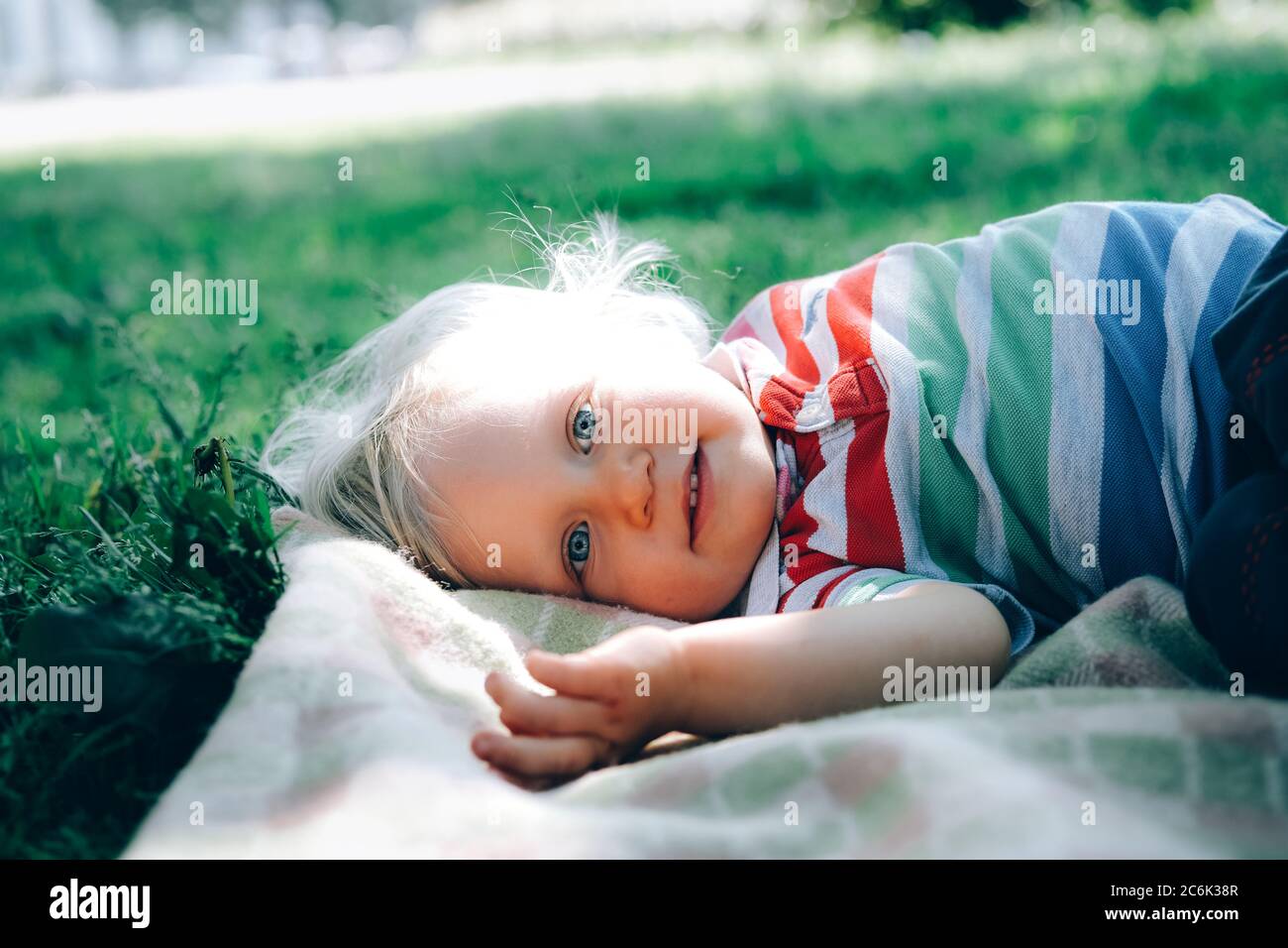 Portrait of a cute happy little boy with blond hair and blue eyes ...