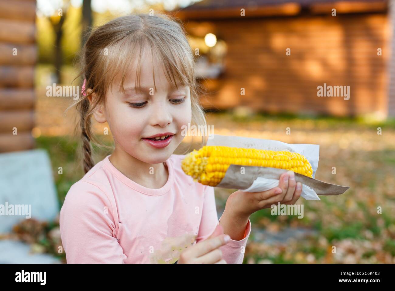 little girl eating messy corn on the cob Stock Photo - Alamy