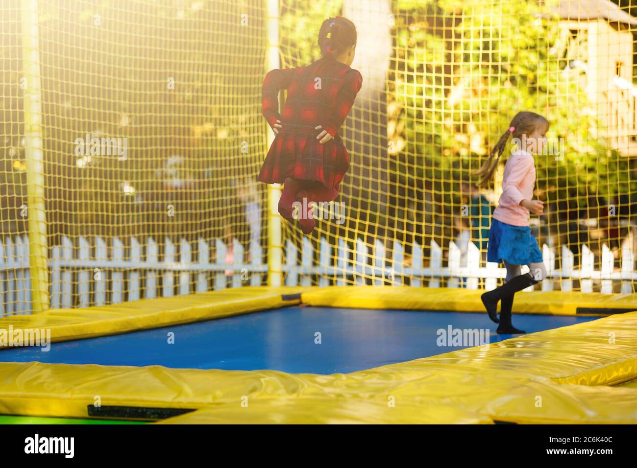 Happy school girl jumping on trampoline in the autumn park Stock Photo ...