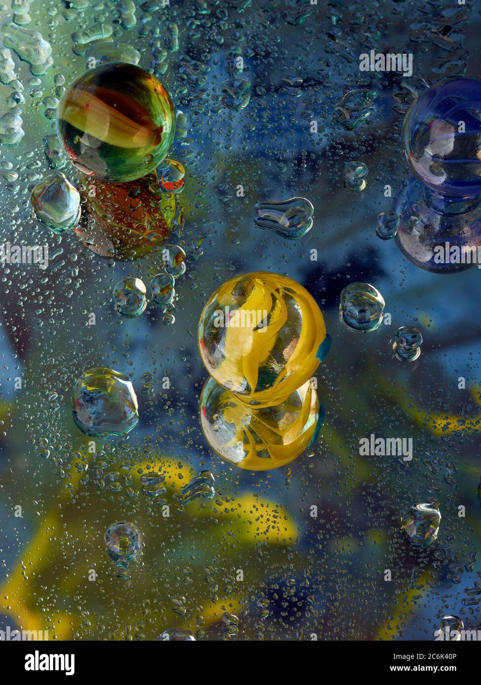 Coloured glass marbles with a background of colour infused water ...
