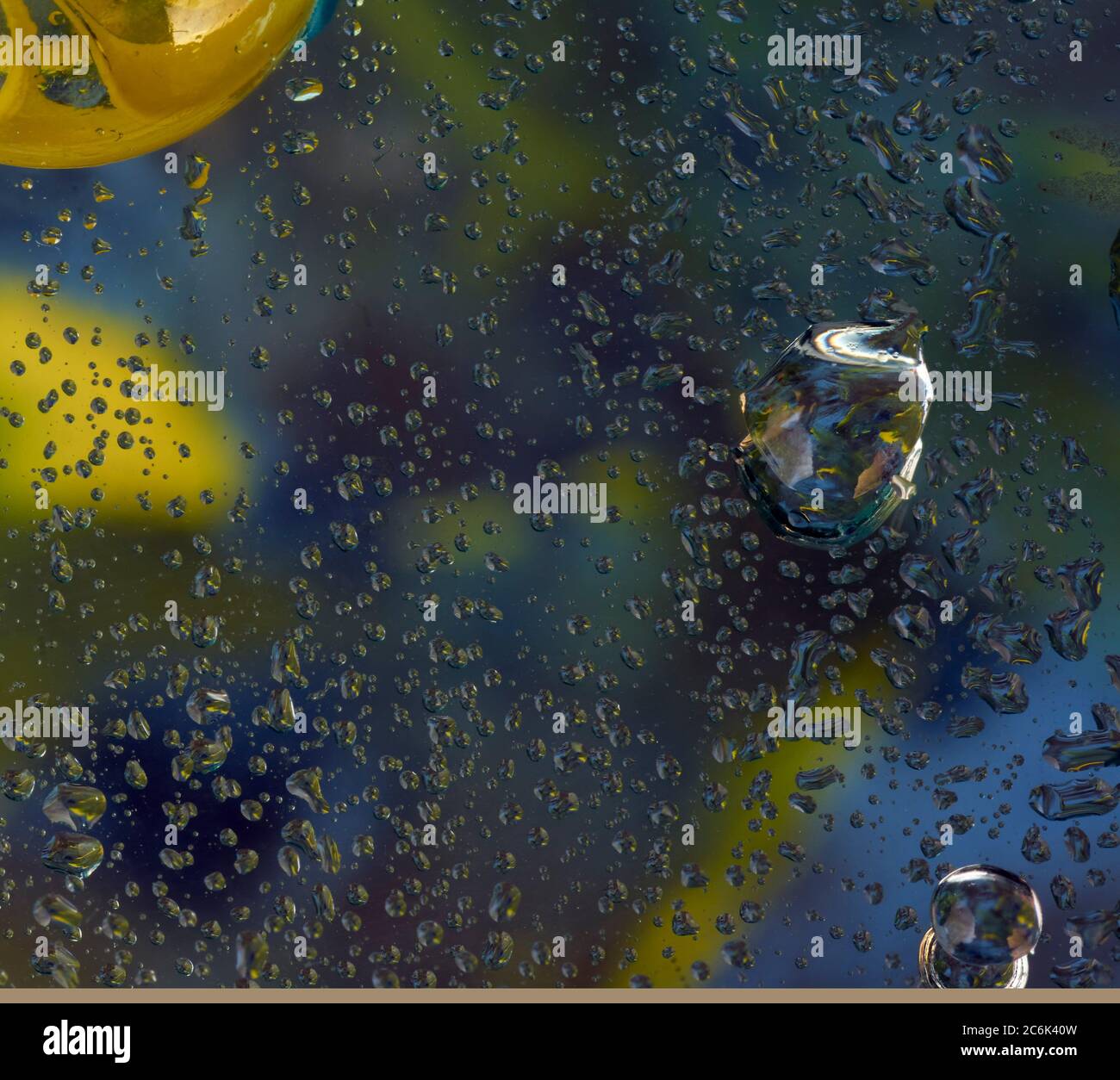 Coloured glass marbles with a background of colour infused water ...