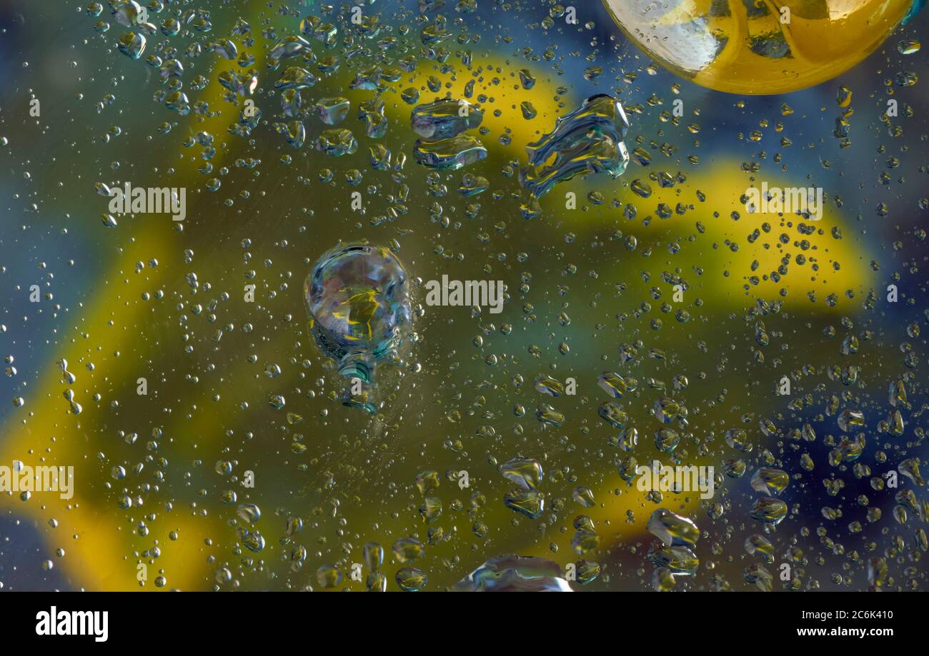 Coloured glass marbles with a background of colour infused water ...