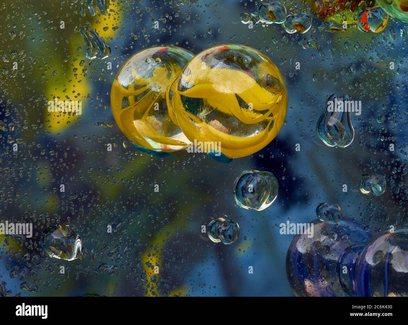Coloured glass marbles with a background of colour infused water ...