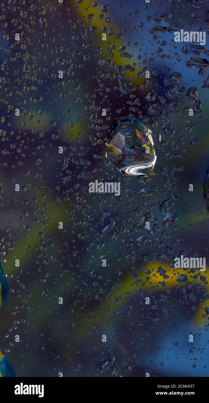 Coloured glass marbles with a background of colour infused water ...