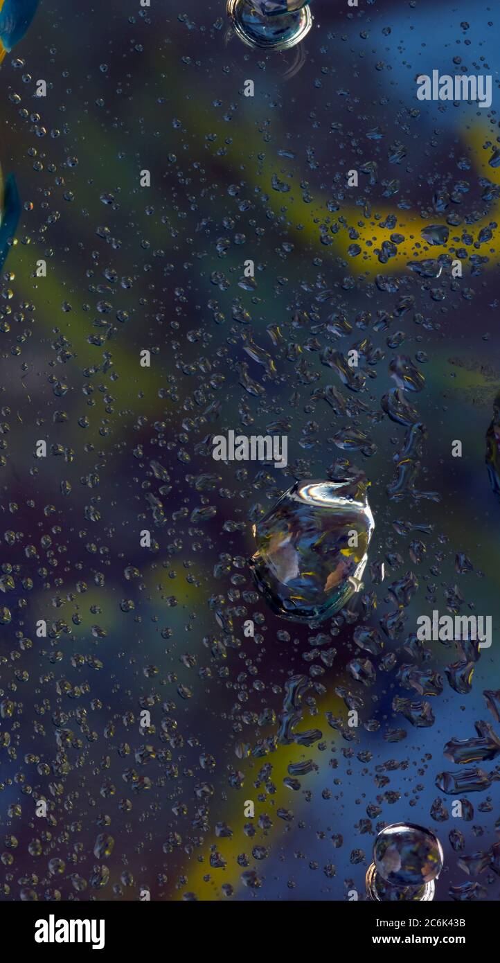 Coloured glass marbles with a background of colour infused water ...