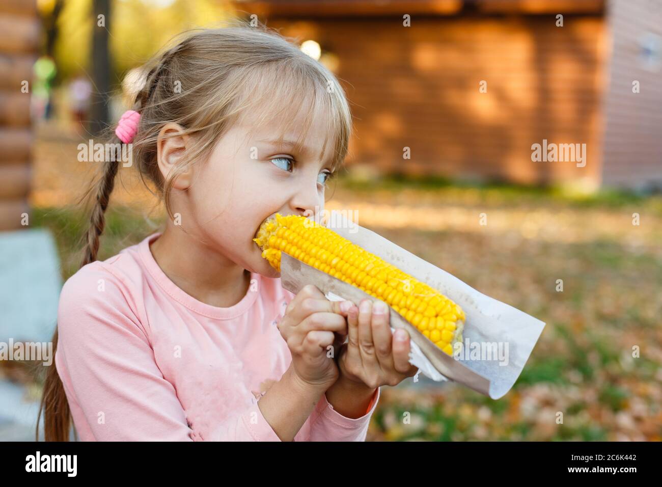little girl eating messy corn on the cob Stock Photo - Alamy