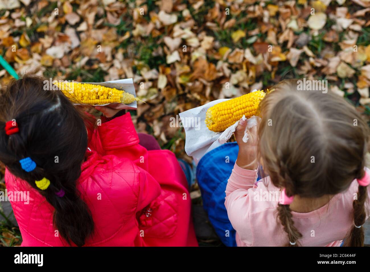 little girls eating messy corn on the cob Stock Photo - Alamy