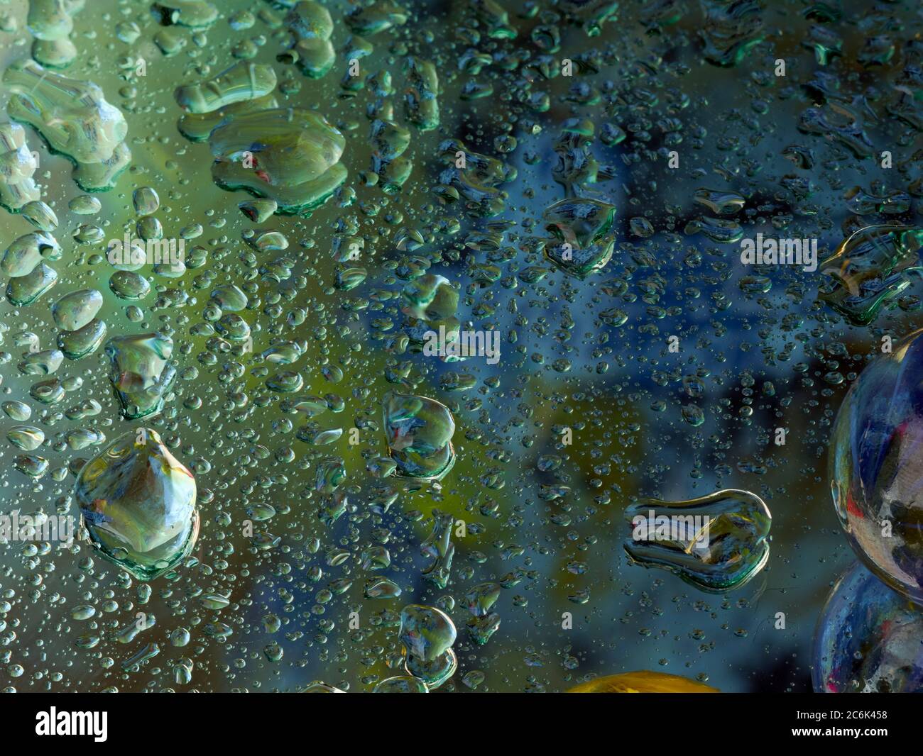 Coloured glass marbles with a background of colour infused water ...