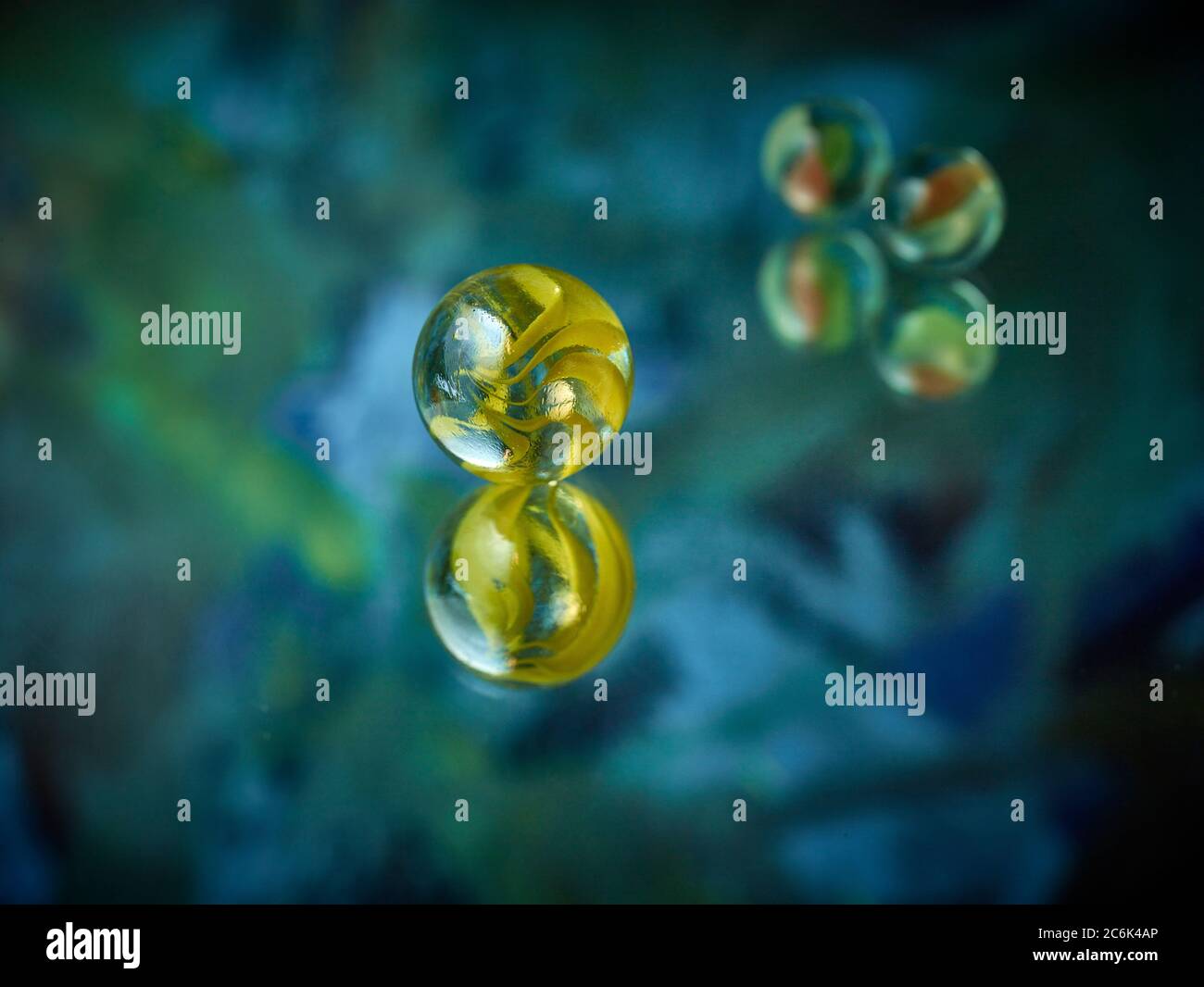 Coloured glass marbles with a background of colour infused water ...