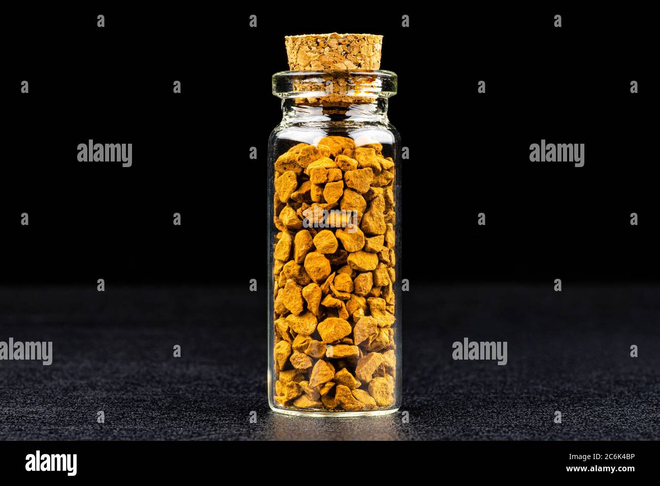 Macro shot of instant coffee in a small glass bottle closed with a cork ...