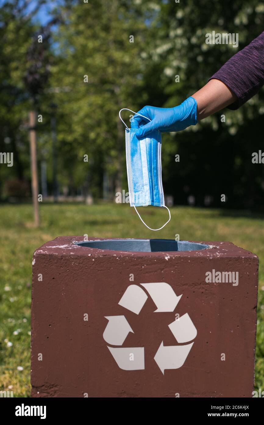 disposing of protective mask in recycle bin Stock Photo - Alamy