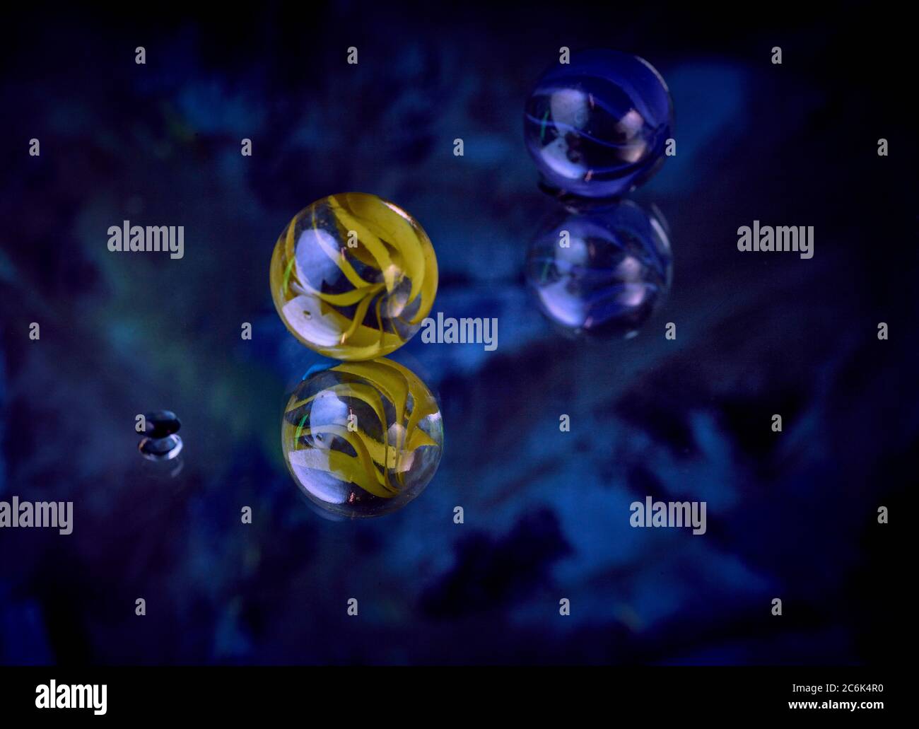 Single glass marble and reflection with a colour infused background and ...