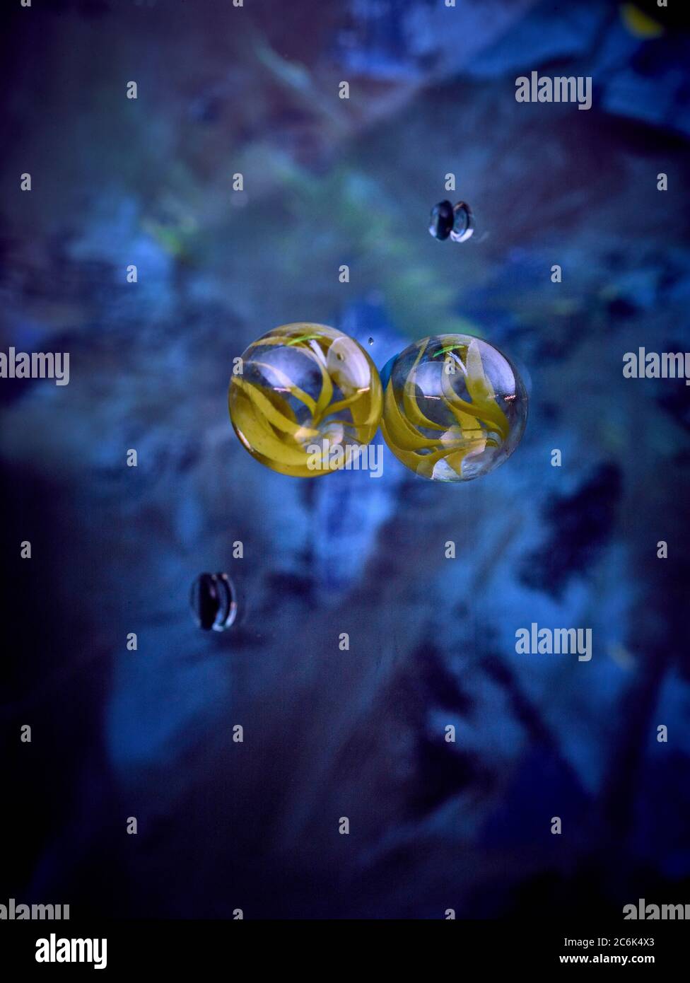 Single glass marble and reflection with a colour infused background and ...