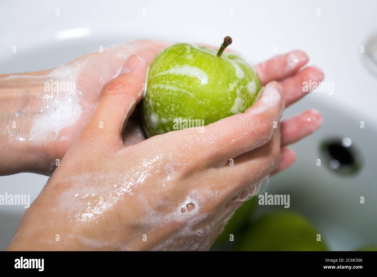 Washing fruit. Girl washes apples. Hands and soapy green apple Stock ...