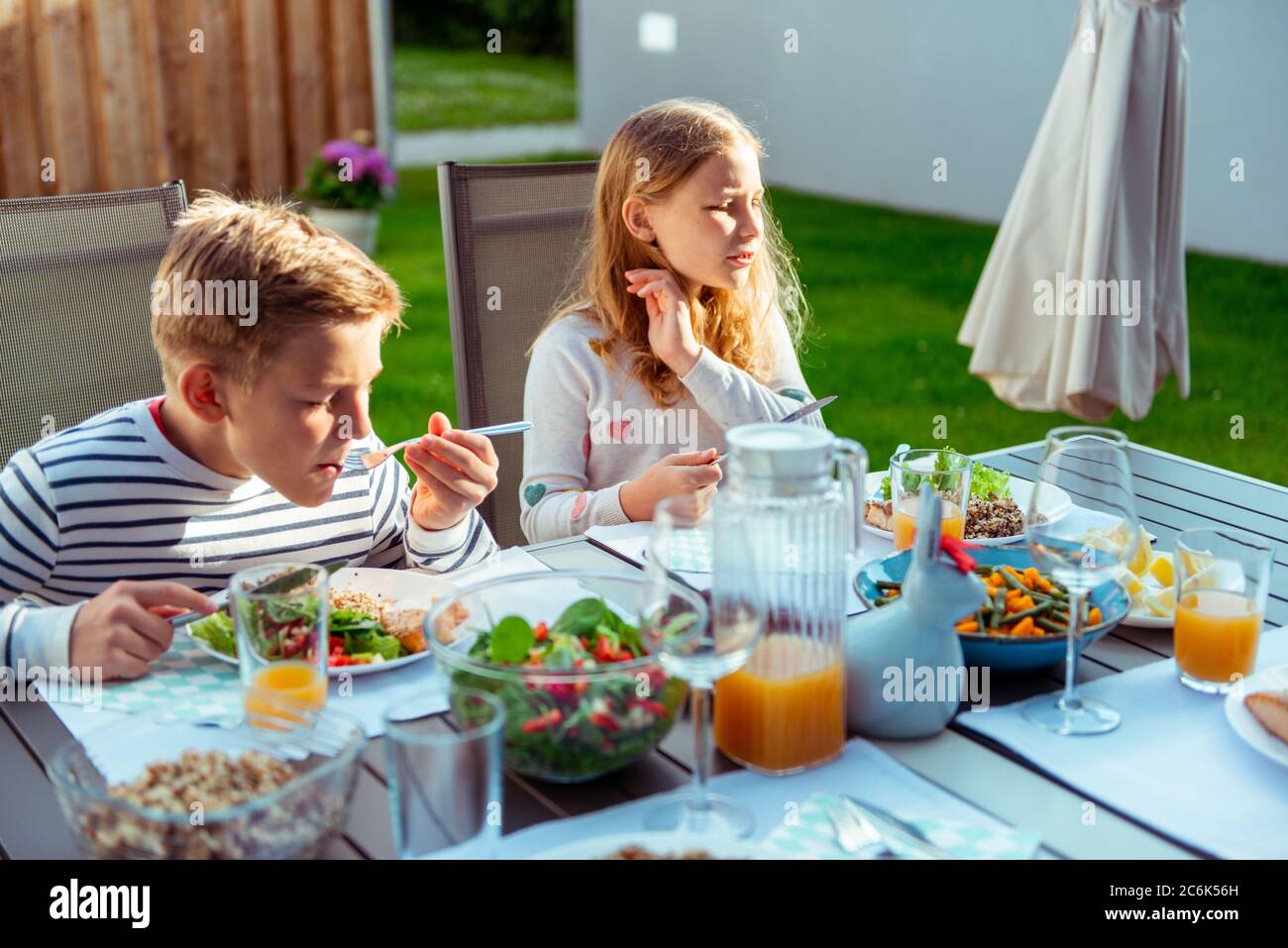 Happy family with two teen children eating healthy dinner together on ...