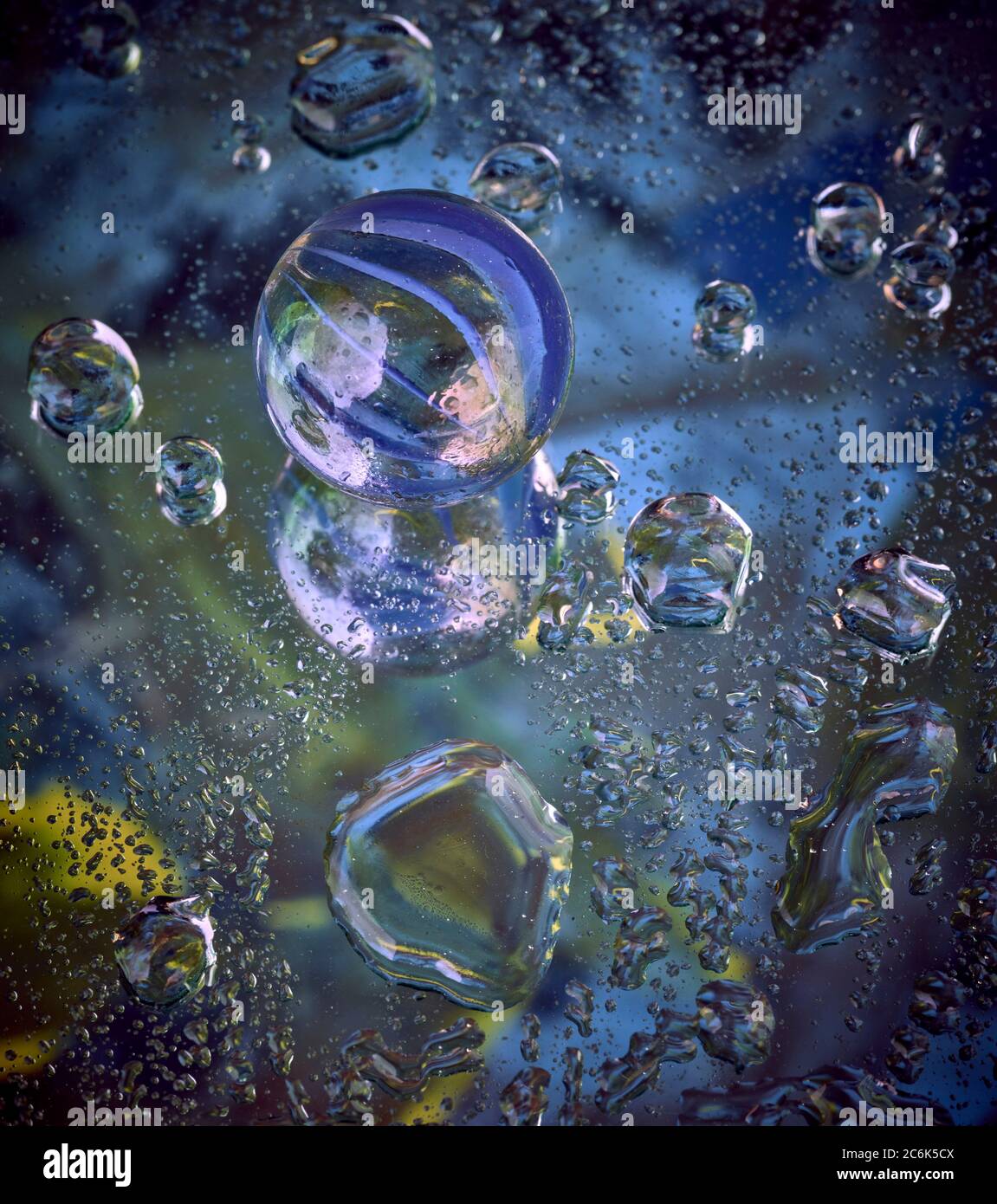 Coloured glass marbles with a background of colour infused water ...