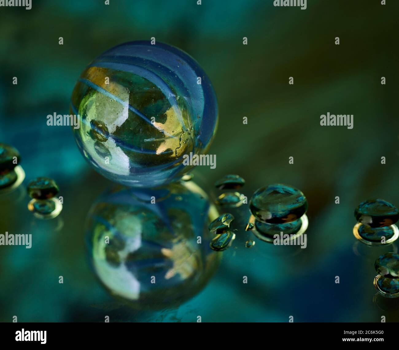 Coloured glass marbles with a background of colour infused water ...