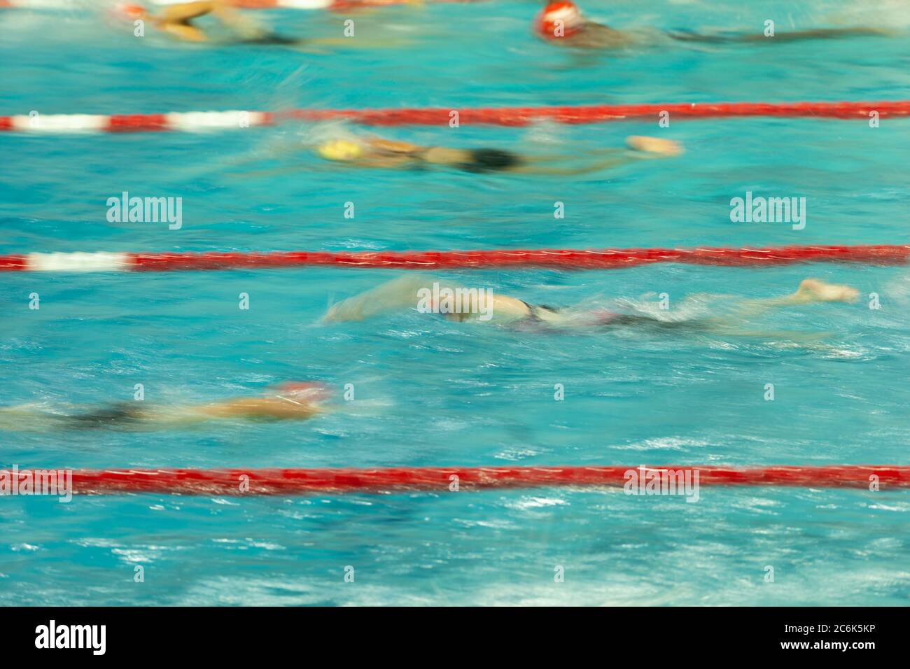 Competitive swimmers warm up in a pool before racing. The image was ...
