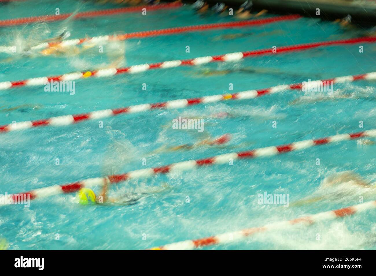 Competitive swimmers warm up in a pool before racing. The image was ...