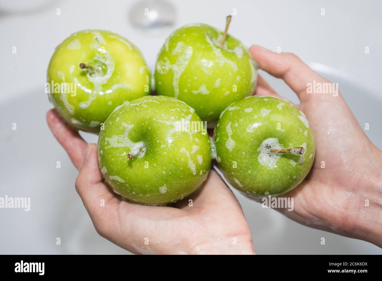 Washing fruit. Girl washes apples. Hands and soapy green apple Stock ...