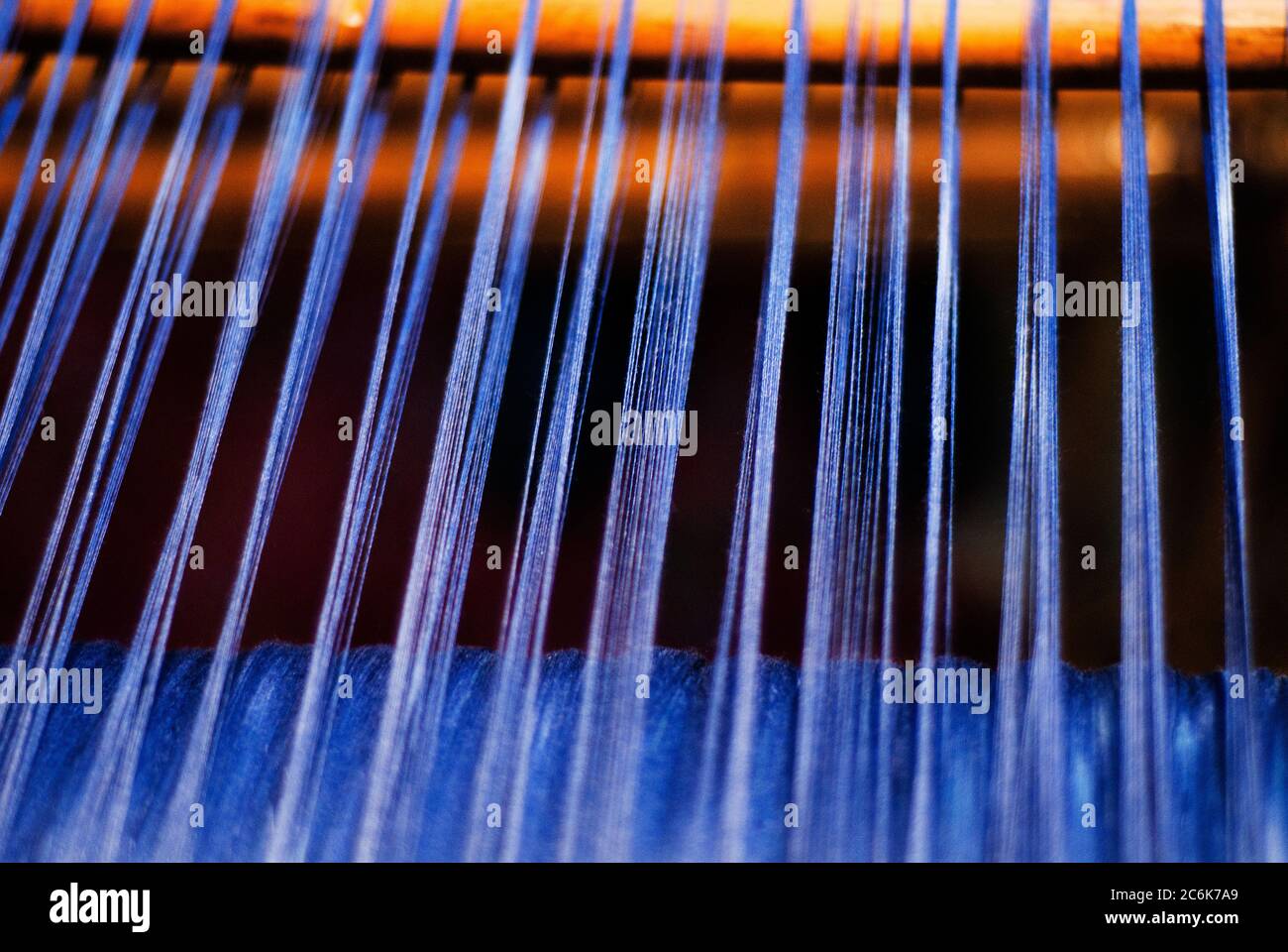 Detail of blue thread being woven at a loom Stock Photo - Alamy
