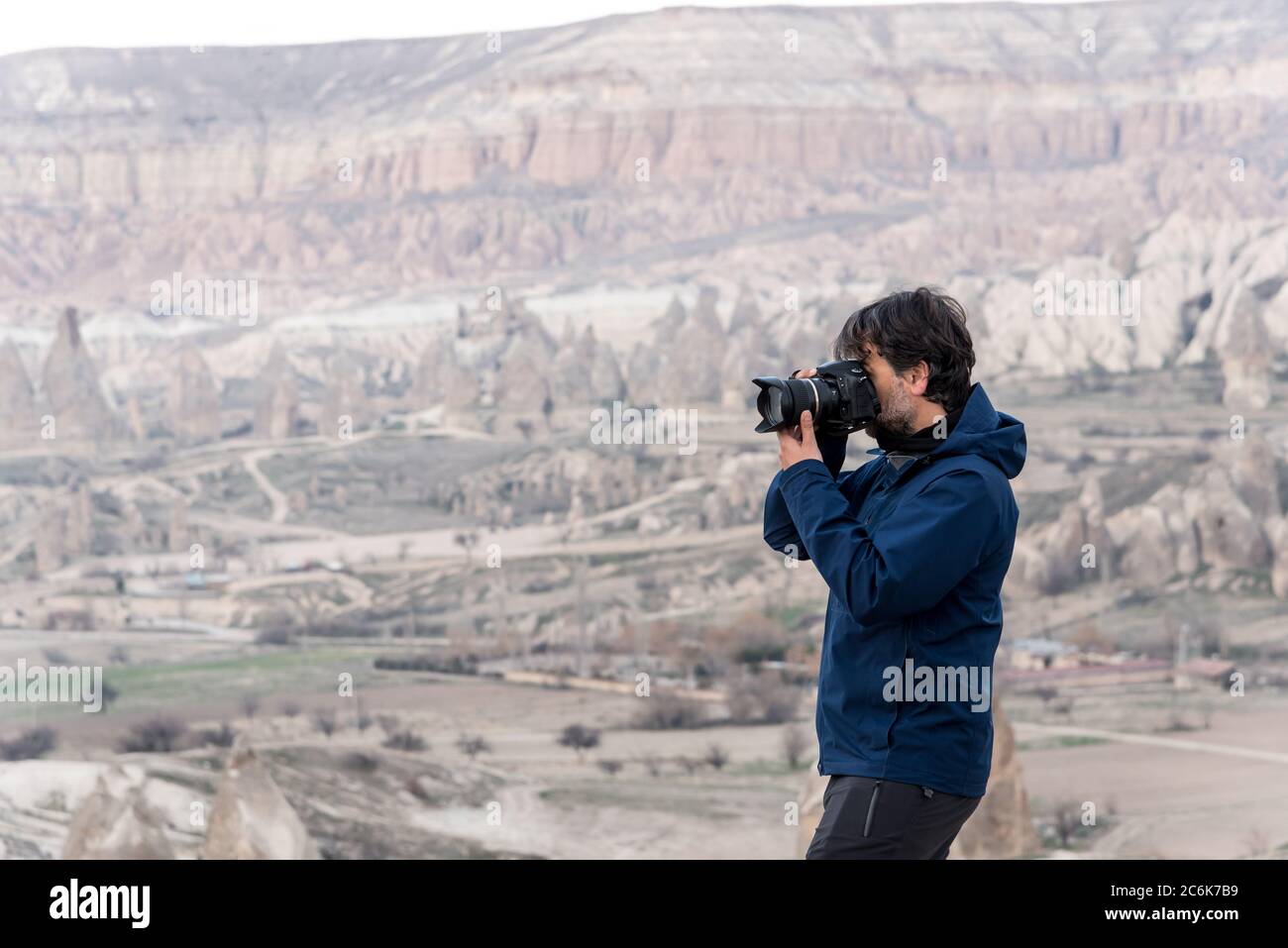 Side view of adult photographer man taking shots of the hills in ...