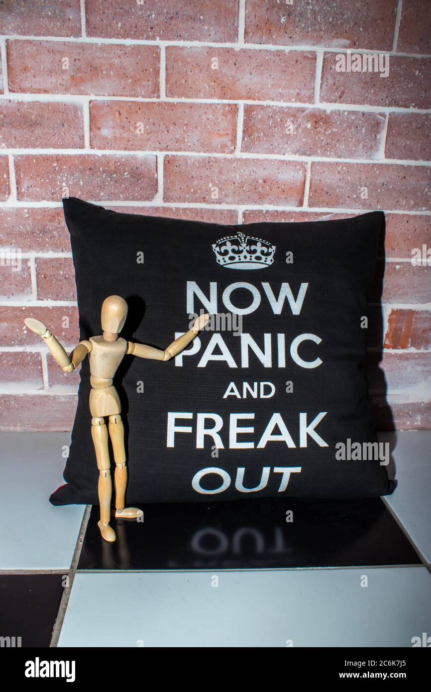 Wooden Human Manikin posing with a black cushion with white words ...
