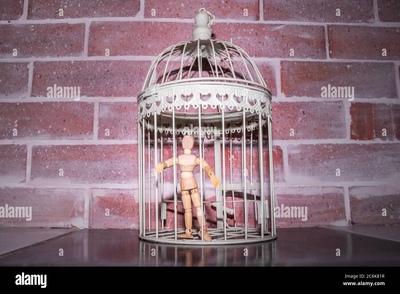 Wooden Human Manikin locked inside a white ornamental bird cage Stock ...