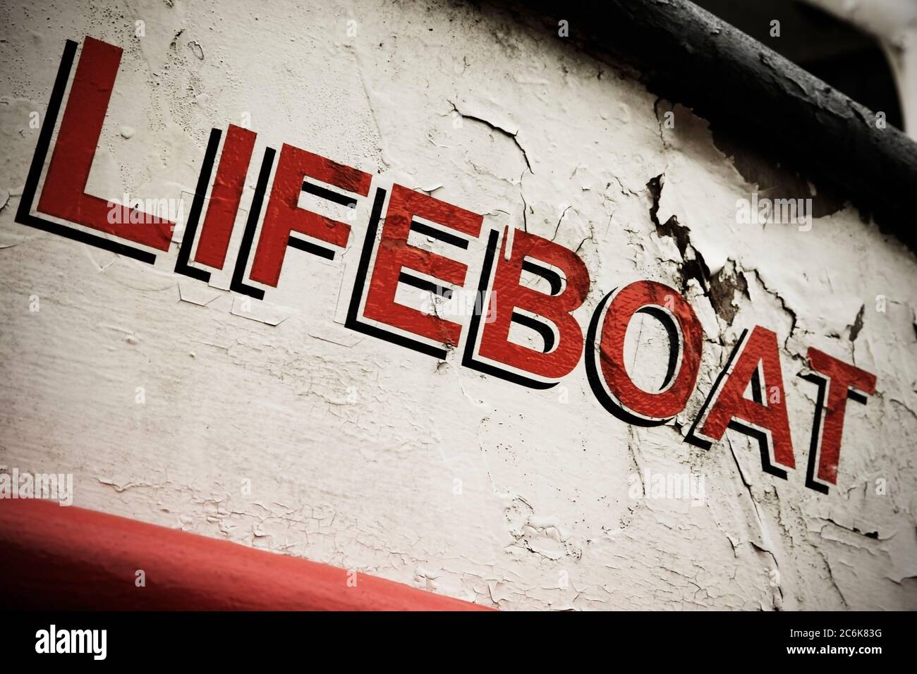 Peeling and aged "lifeboat" wording on the side of old disused British ...