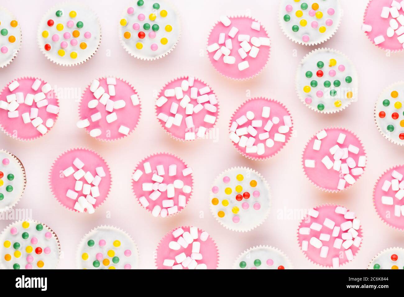 Multiple colorful nicely decorated muffins on a white background, top ...