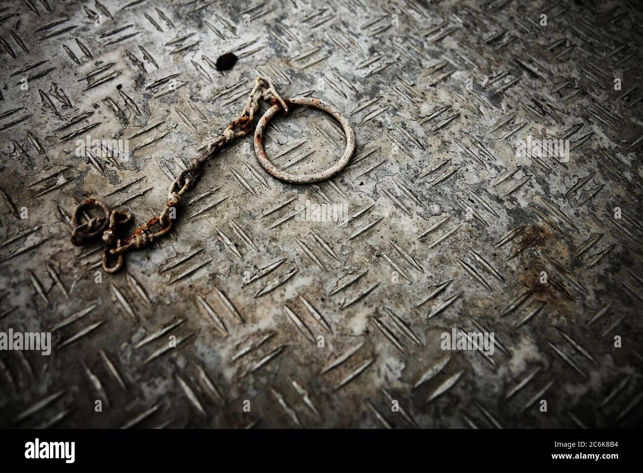 Length of old chain and ring on dirty checkerplate Stock Photo - Alamy