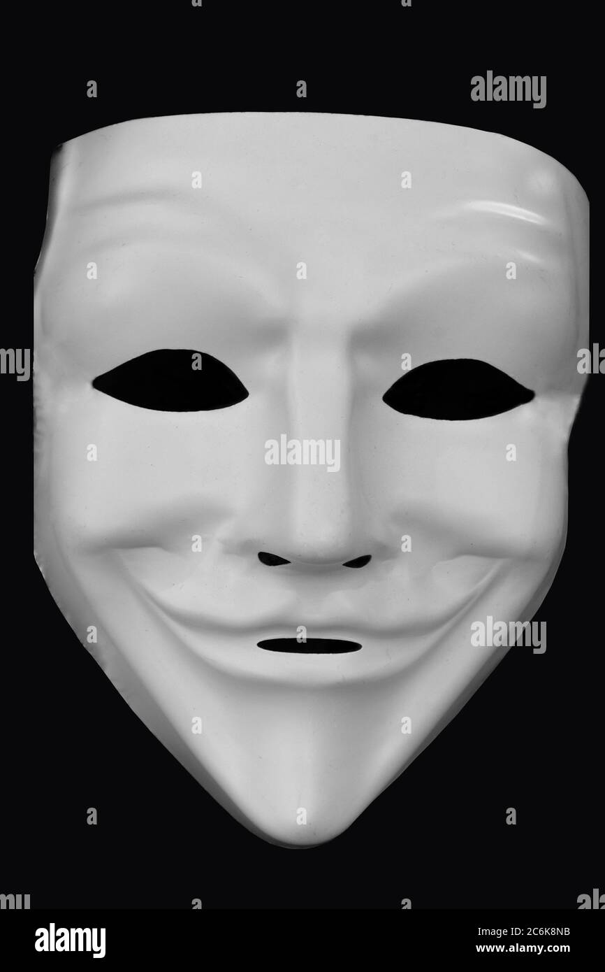 Anonymous white mask isolated on a black background Stock Photo - Alamy