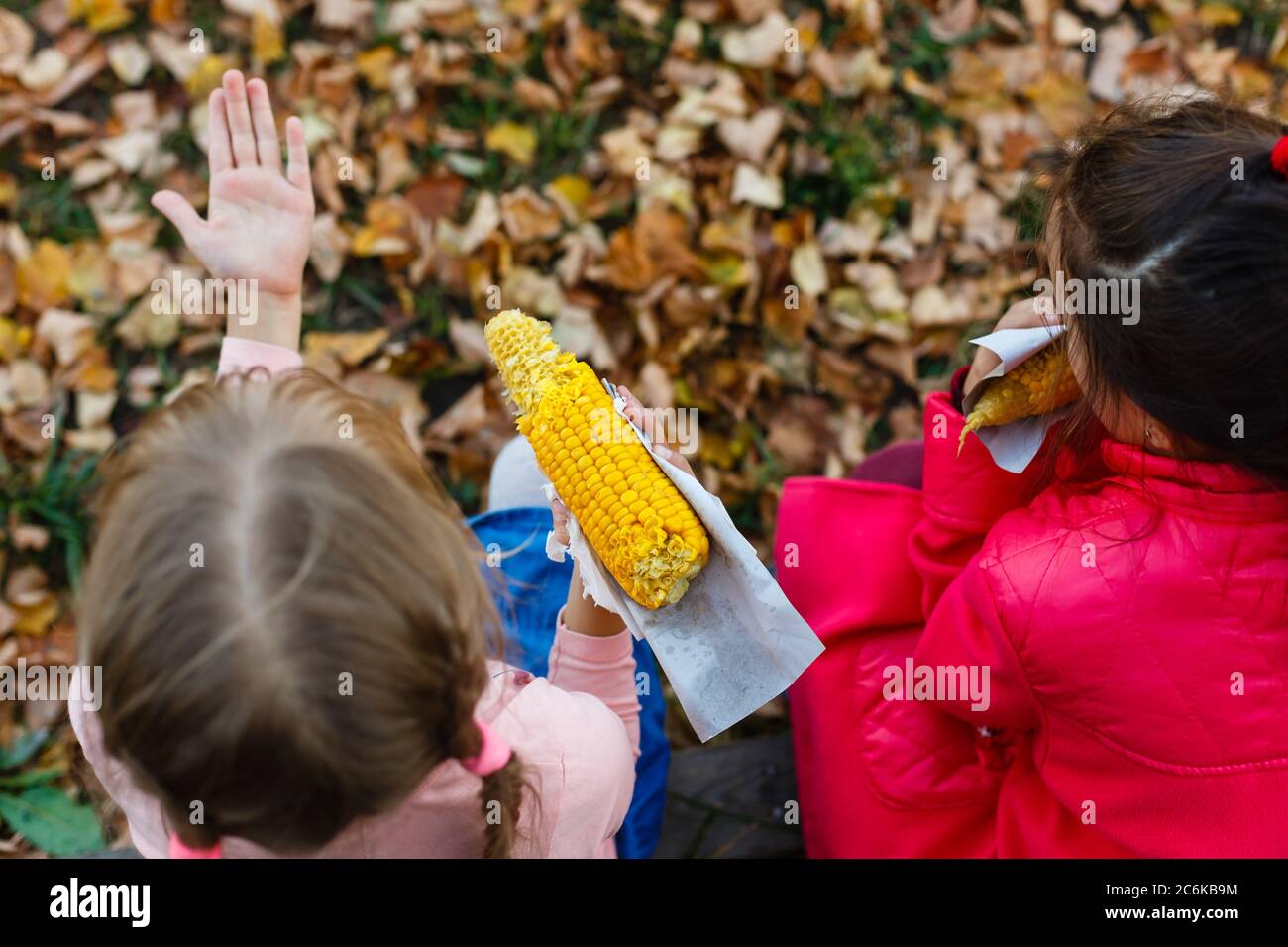 little girls eating messy corn on the cob Stock Photo - Alamy