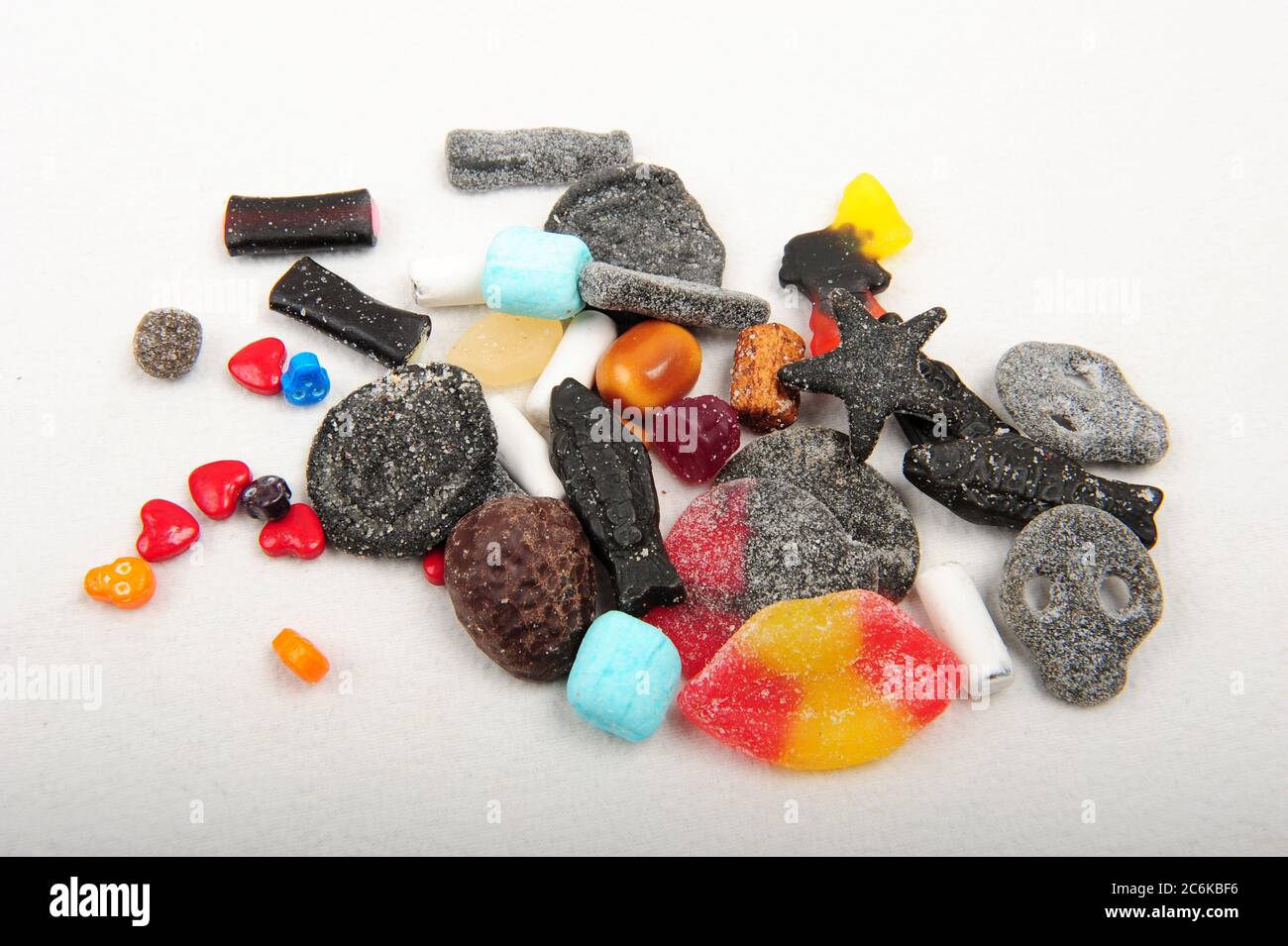 Salt, sour and sweet candy spread out on white background. Super salt ...